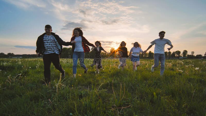 Merry Friends Run Off into the Sunset Holding Hands. Stock Image ...