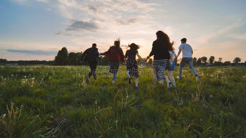 Merry Friends Run Off into the Sunset Holding Hands. Stock Photo ...