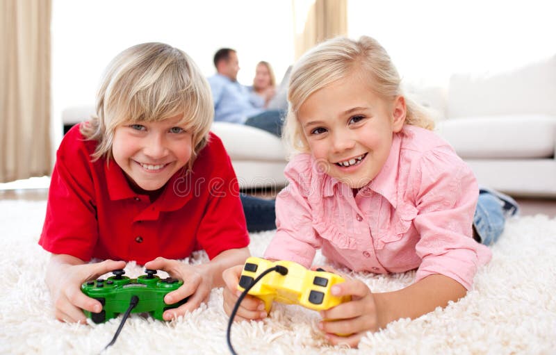 Siblings Playing Video Games Together Stock Photo - Image of lying ...
