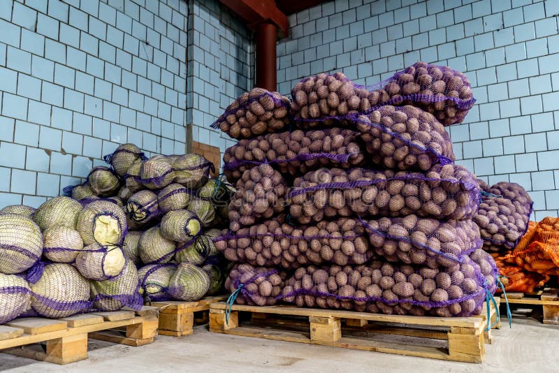 Mesh Bags with Vegetables Potatoes and Cabbage in the Store`s Warehouse ...