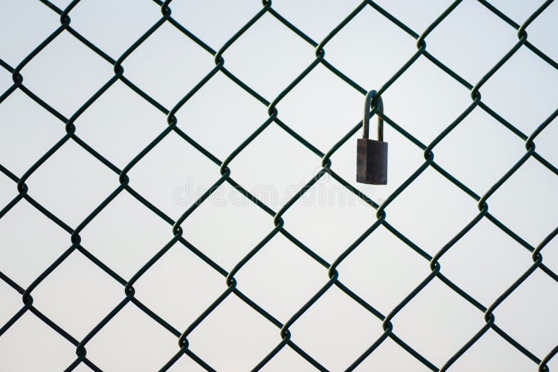 Mesh Wire Fence with Lock on the Sky Background. Stock Image - Image of ...