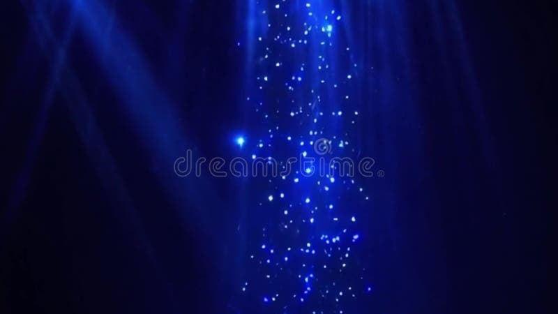 Twinkling Blue Glitter Falling in Glowing Light Rays Stock Video ...