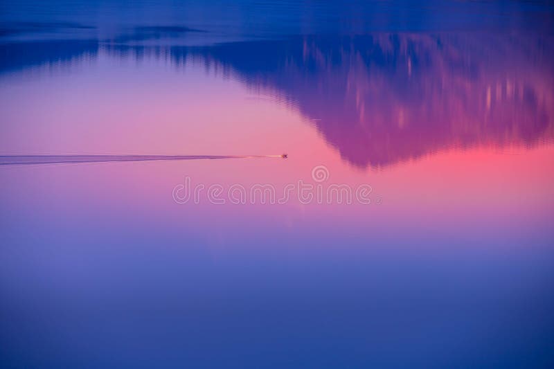 Mesmerizing Landscape Reflected in a Lake with a Boat at Sunset Stock ...