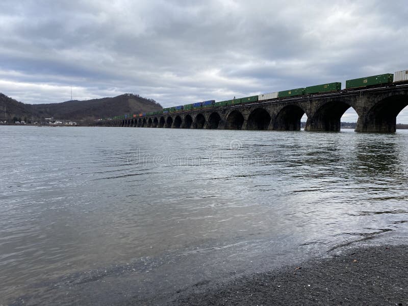 Mesmerizing Shot of Freight Train Passing the Arch Bridge Over the ...
