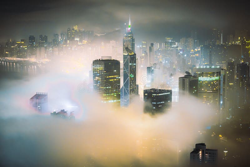 Mesmerizing Shot of the Skyscrapers of a City Covered in Mist at Night ...