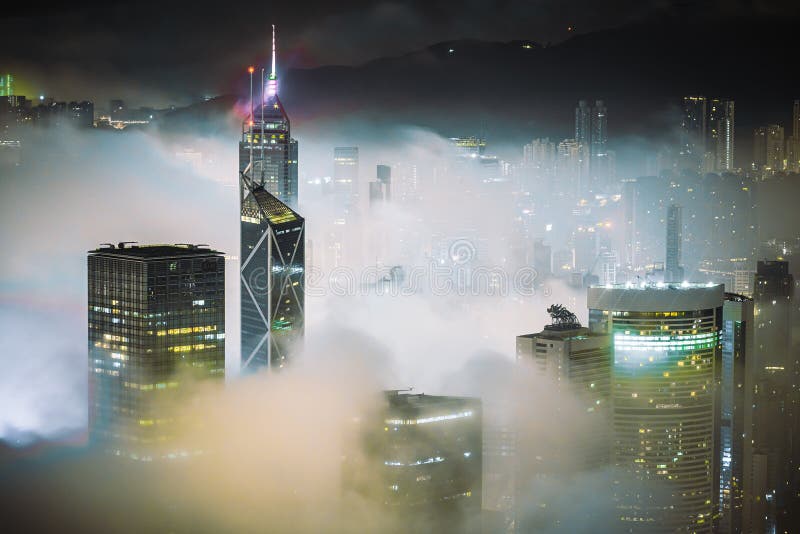 Mesmerizing Shot of the Skyscrapers of a City Covered in Mist at Night ...