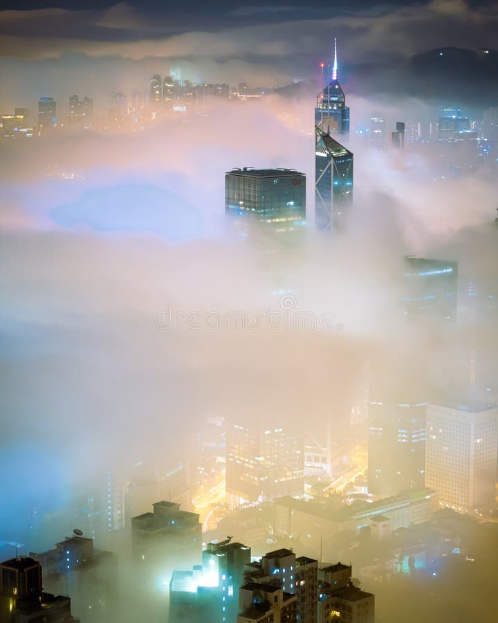 Mesmerizing Shot of the Skyscrapers of a City Covered in Mist at Night ...