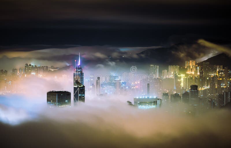 Mesmerizing Shot of the Skyscrapers of a City Covered in Mist at Night ...