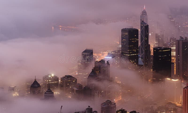 Mesmerizing Shot of the Skyscrapers of a City Covered in Mist at Night ...
