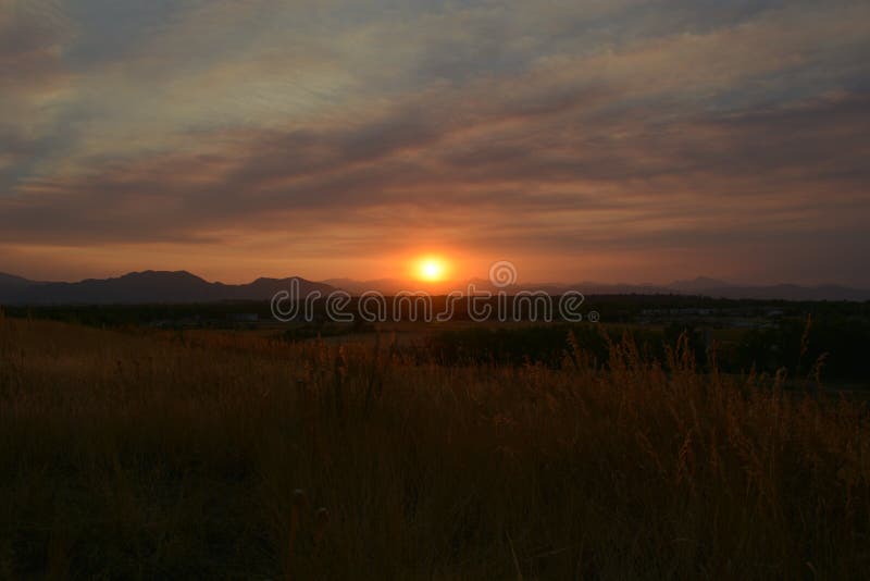 Mesmerizing Sunset Over the Field with Mountains in the Background in ...
