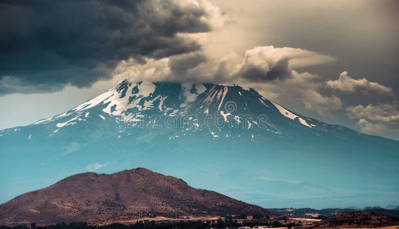 Mesmerizing View of a Huge Mountain Covered in Snow with a Small Hill ...