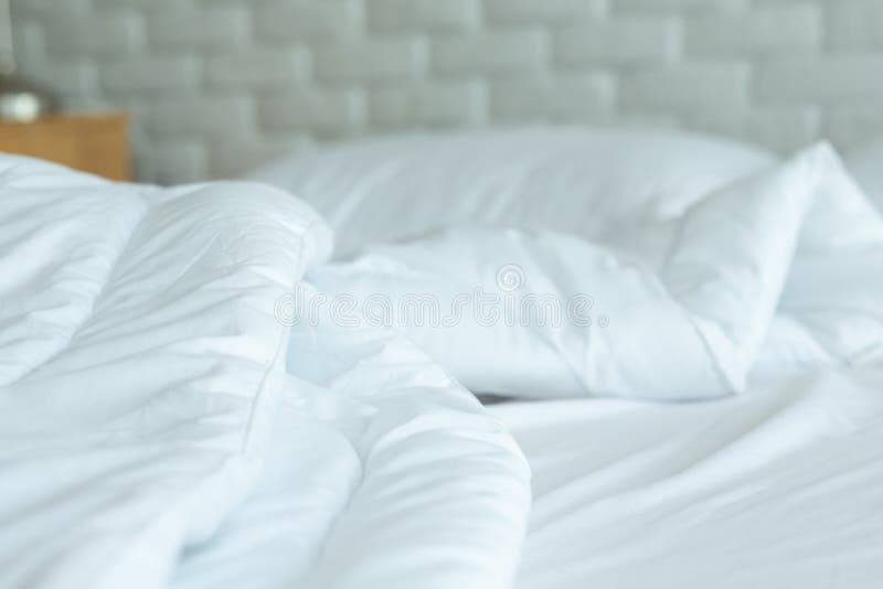 Messed Bed with White Pillow and Blanket with Natural Light in Bedroom ...