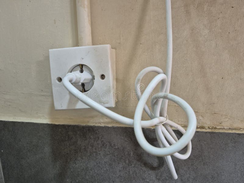 Messy Tangled White Cable Plugged into a Dirty Wall Socket. Unsafe ...