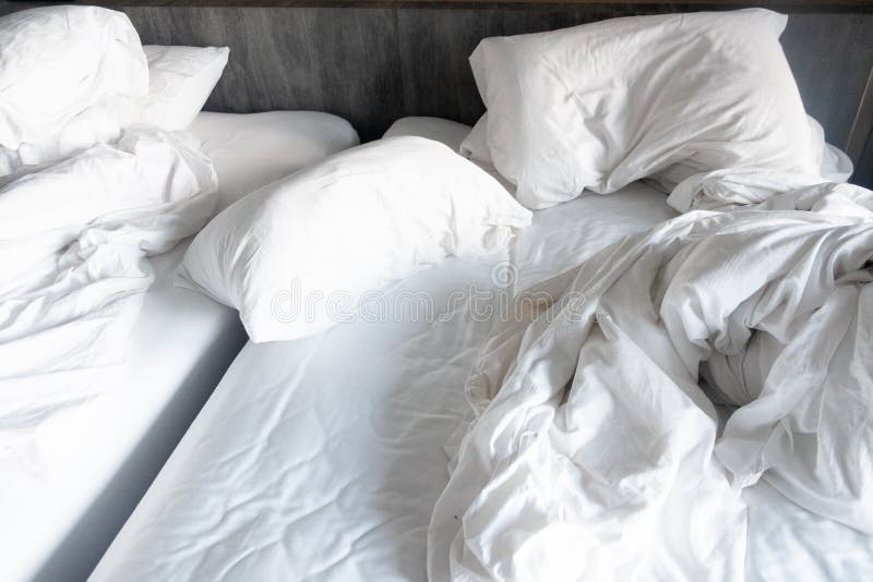 Messy White Bedding Sheets and Pillows with Wrinkles on Bed Stock Image ...