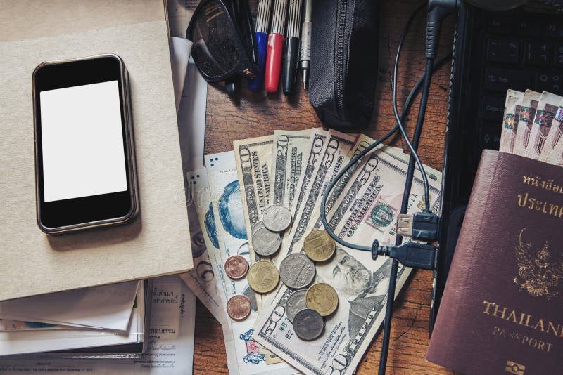 Messy Working Table, with Cash, Passport, Smartphone, Laptop, and Etc ...