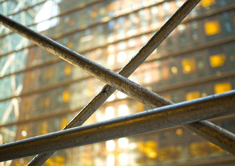 Metal Bars in Front of a Glass Building with Yellow Glowing Windows ...