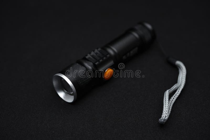 Metal Black Flashlight on a Black Background. Pocket Flashlight Stock ...