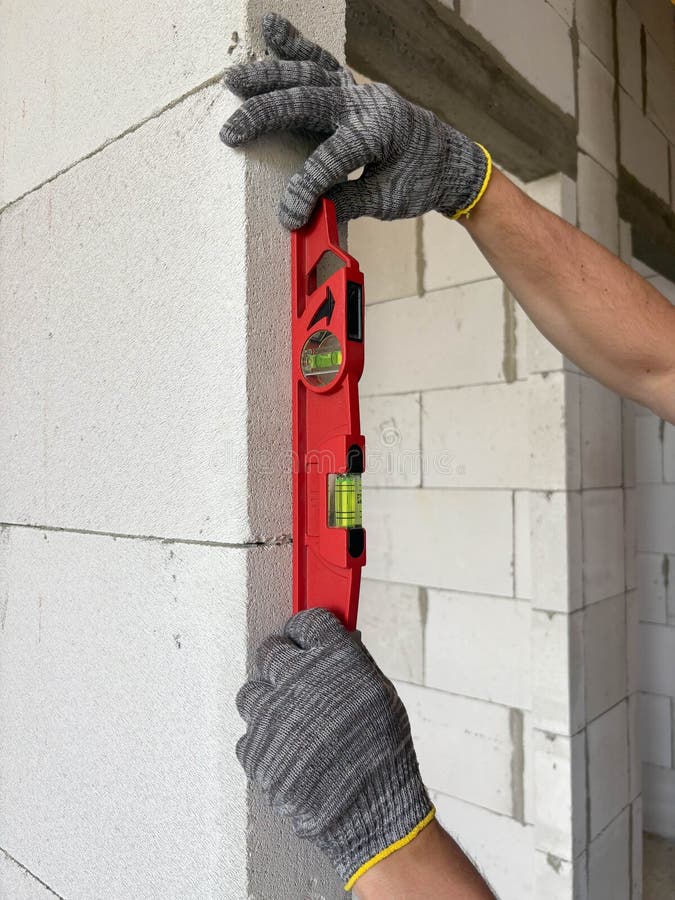 A Metal Bubble Level is Applied To the Wall To Check for Levelness ...