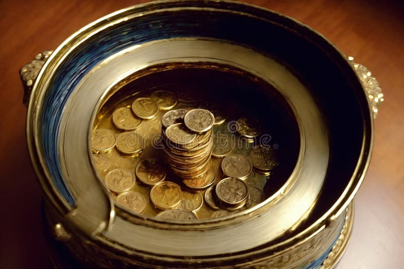 A Metal Container Filled with Coins on Top of a Wooden Table ...
