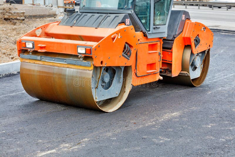 The Large Vibratory Road Roller Compacts Fresh Asphalt on a New Road ...