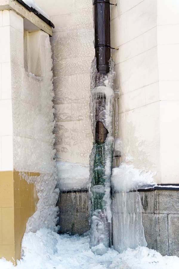 A Metal Drain Pipe is Covered with Ice Near the Wall Stock Photo ...