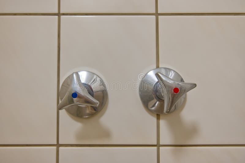 Metal Faucet Knobs on Tiled Wall for Hot and Cold Water Stock Photo ...