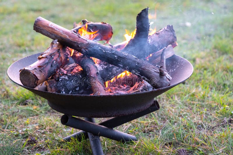 Metal Fire Bowl with Burning Wood in the Yard. Safe Decorative Fire Pit ...