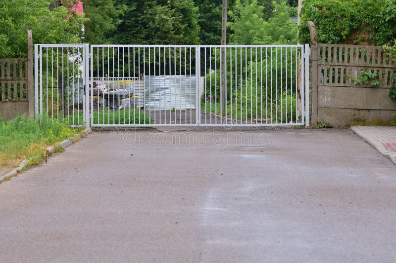 Metal Gate at the End of the Asphalt Road. Day Stock Image - Image of ...