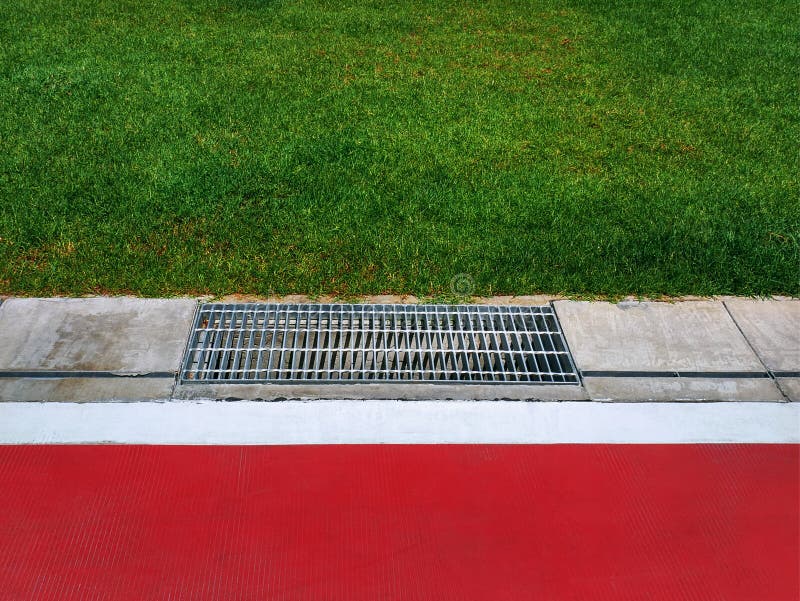 Metal Grating by Red Floor and Green Grass Field Stock Image - Image of ...