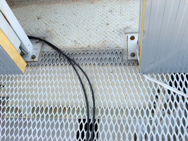 A Metal Grid Floor Featuring a Diamond Pattern is Intersected by ...