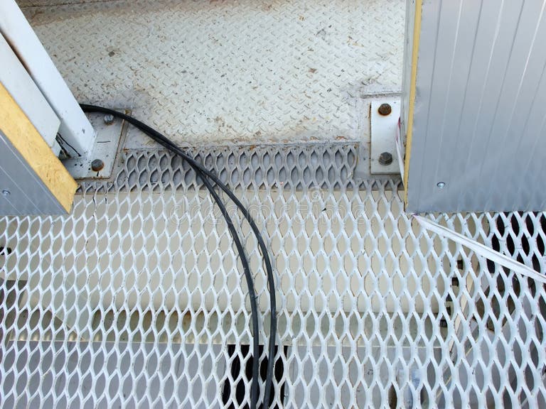 A Metal Grid Floor Featuring a Diamond Pattern is Intersected by ...