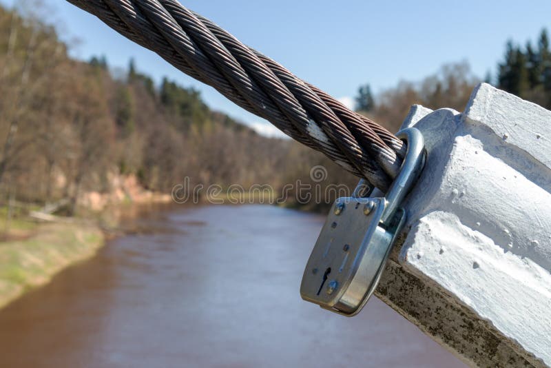 Metal Key Hooked and Locked on Metal Rope with River and Tree ...
