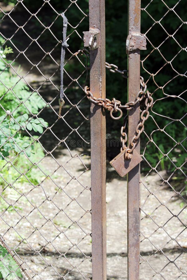 Metal Lock Closes the Gate with a Chain and Key is Hanging Near Stock ...