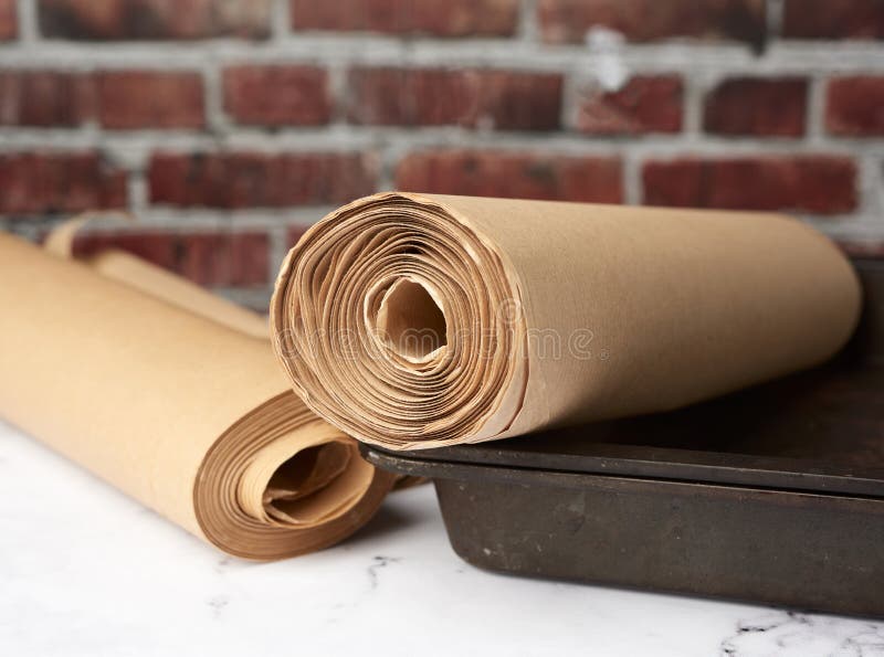 Metal Pan and Rolls of Brown Parchment Paper on a White Table Stock ...