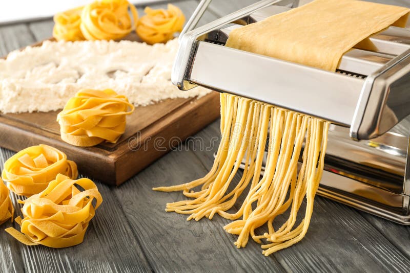 Metal Pasta Maker with Dough on Kitchen Table Stock Photo - Image of ...