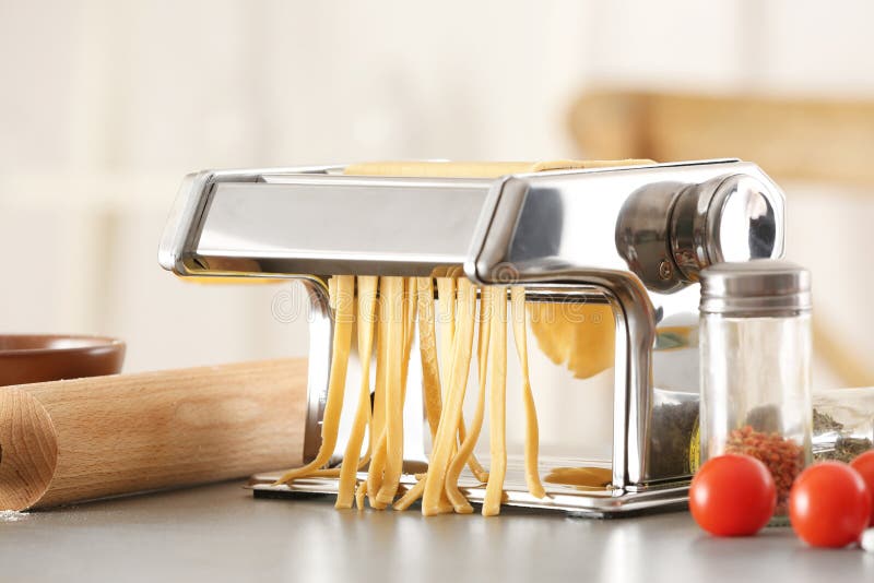 Metal Pasta Maker with Dough on Kitchen Table Stock Photo - Image of ...