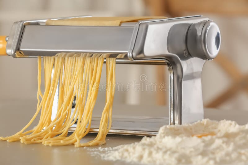 Metal Pasta Maker with Dough on Kitchen Table Stock Photo - Image of ...