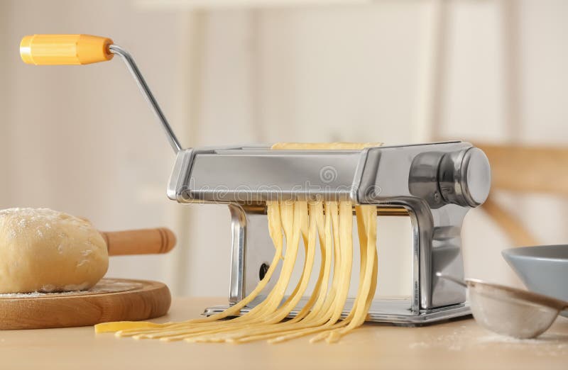 Metal Pasta Maker with Dough on Kitchen Table Stock Photo - Image of ...