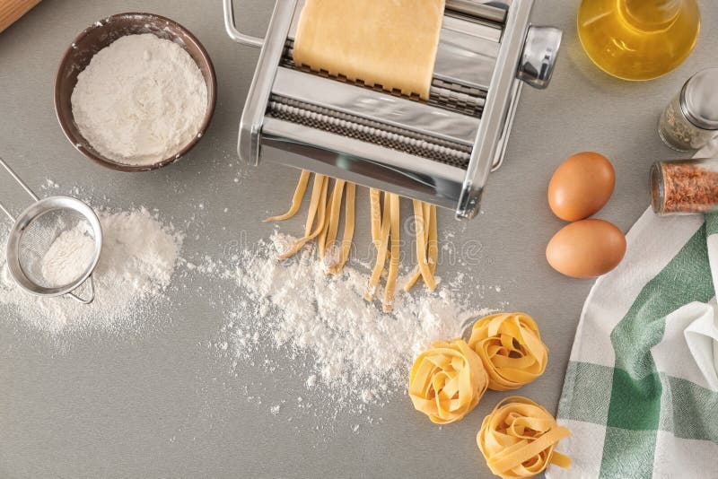 Metal Pasta Maker with Dough on Kitchen Table, Top View Stock Photo ...
