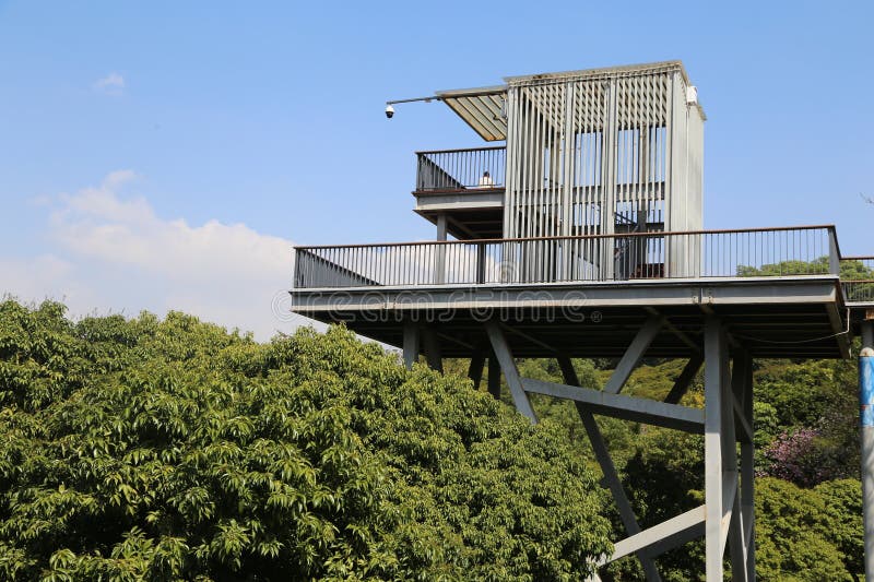 A Metal Platform Tower with Two Floors, Surrounded by Green Trees and a ...