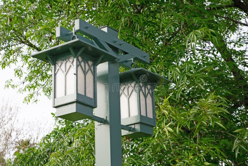 Lantern Style Outdoor Dual Lights on a Metal Post Under a Tree in a ...