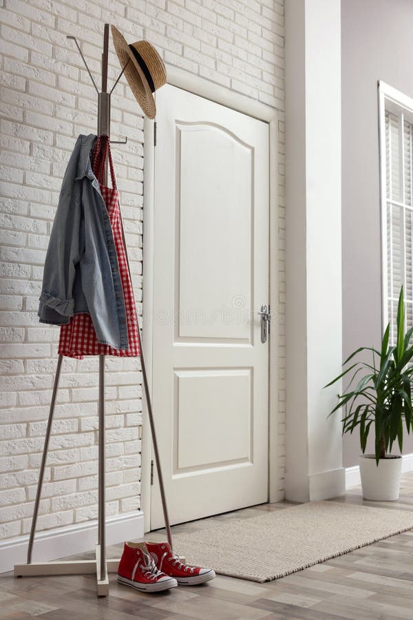 Metal Rack with Clothes and Straw Hat in Hallway Stock Image - Image of ...