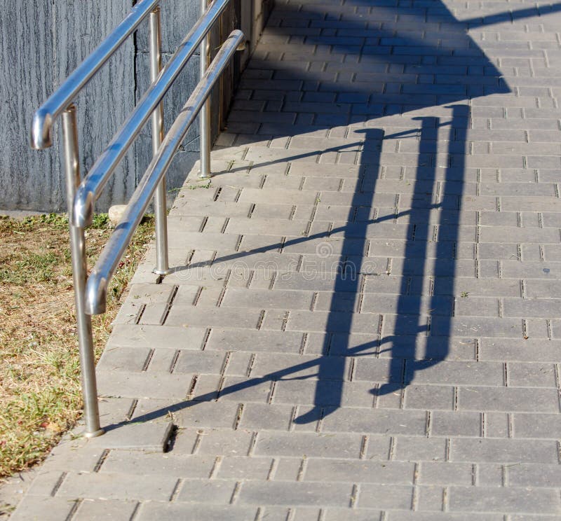 A Metal Railing is on the Side of a Brick Walkway Stock Photo - Image ...