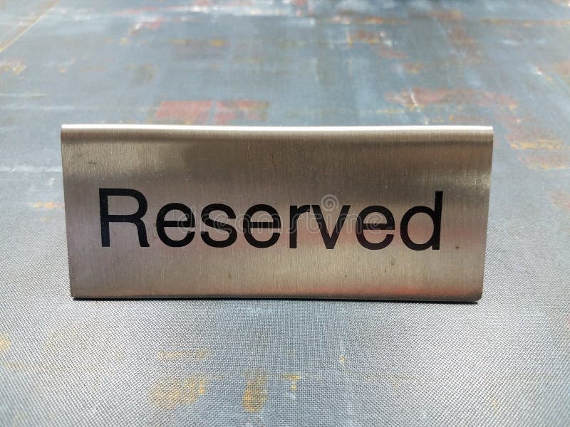 Metal Reserved Sign for Reservation on Green Table Stock Photo - Image ...