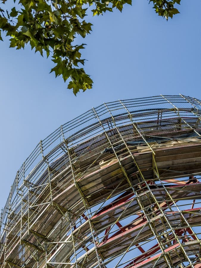 Metal Scaffolding Surrounding a Round Building Under a Blue Sky with ...