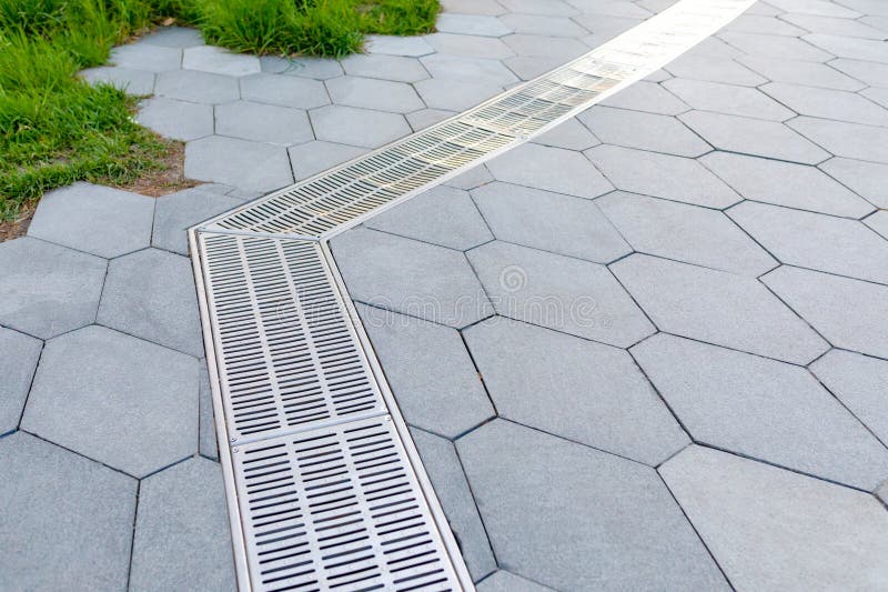 Metal Storm Sewer Grate on Shaped Paving Slabs in Park. Drainage ...