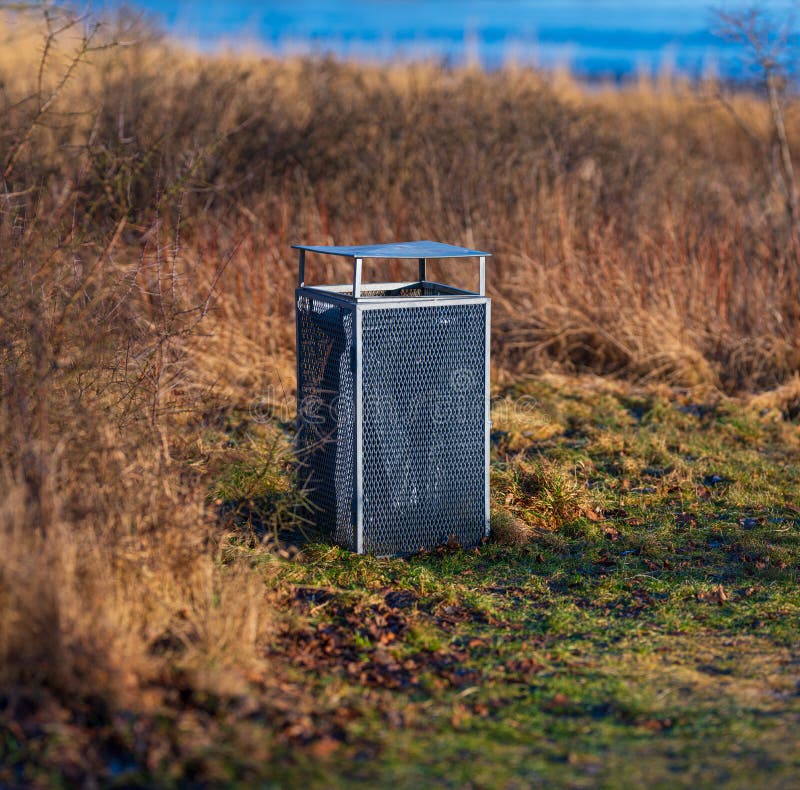 Metal Trash Bin in Grassy Field Near Water.. Stock Image - Image of ...