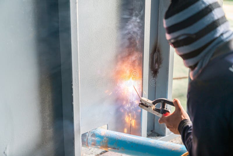 A Metal Welder Welds Metal a Wall in a Warehouse Stock Image - Image of ...