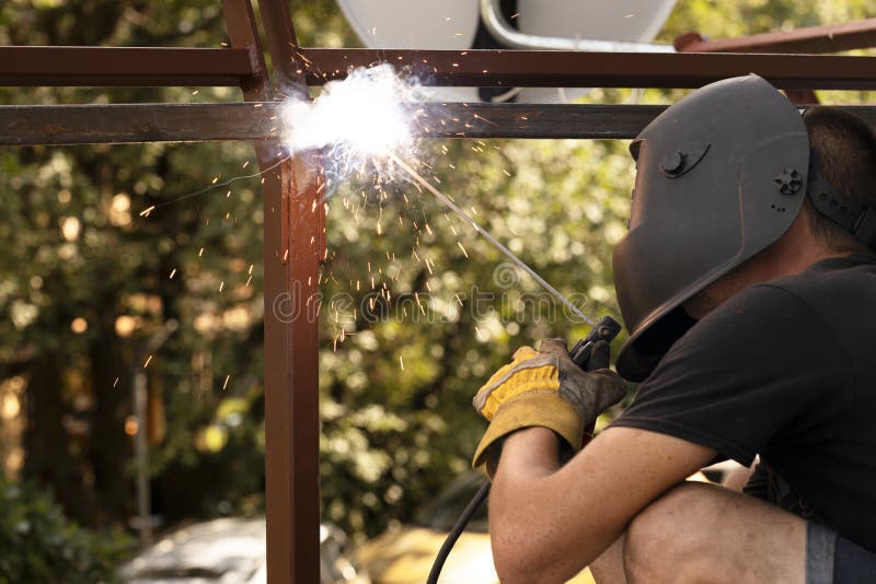Metal Welding in Industrial Production, a Man in a Welding Mask Welds a ...