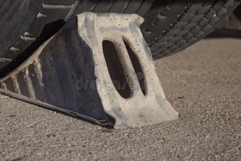 Metal Wheel Chock Under Trailer Stock Photo - Image of pavement, soil ...
